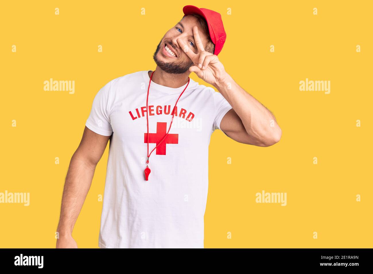 Young caucasian man wearing lifeguard t shirt holding whistle doing ...