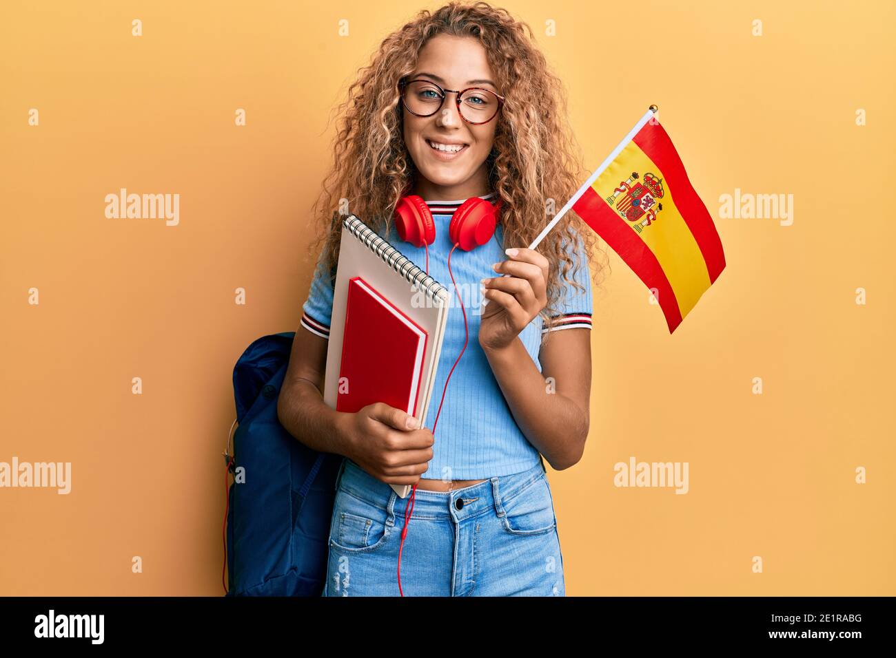 Beautiful caucasian teenager girl exchange student holding spanish flag ...