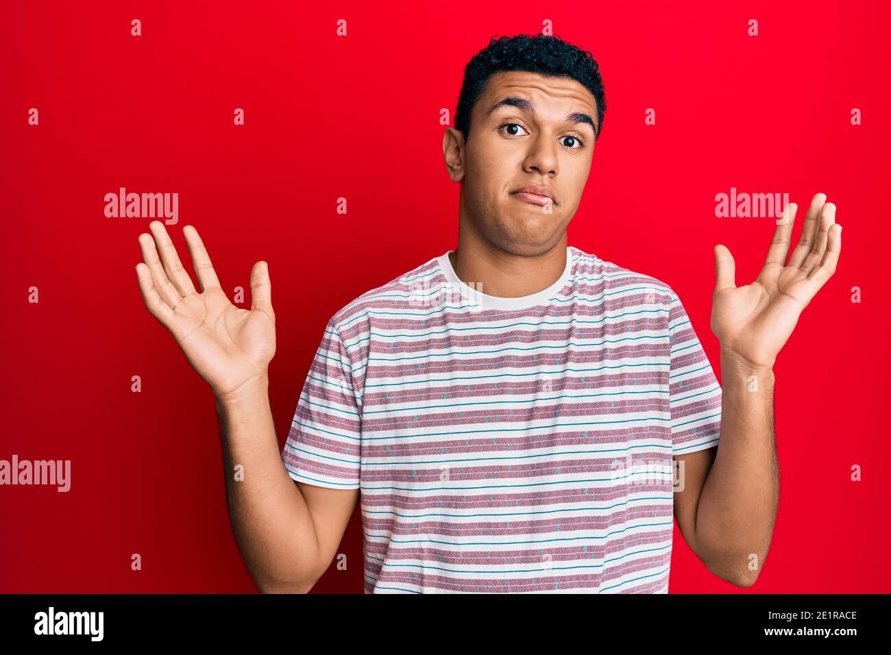 Young arab man wearing casual clothes clueless and confused with open ...