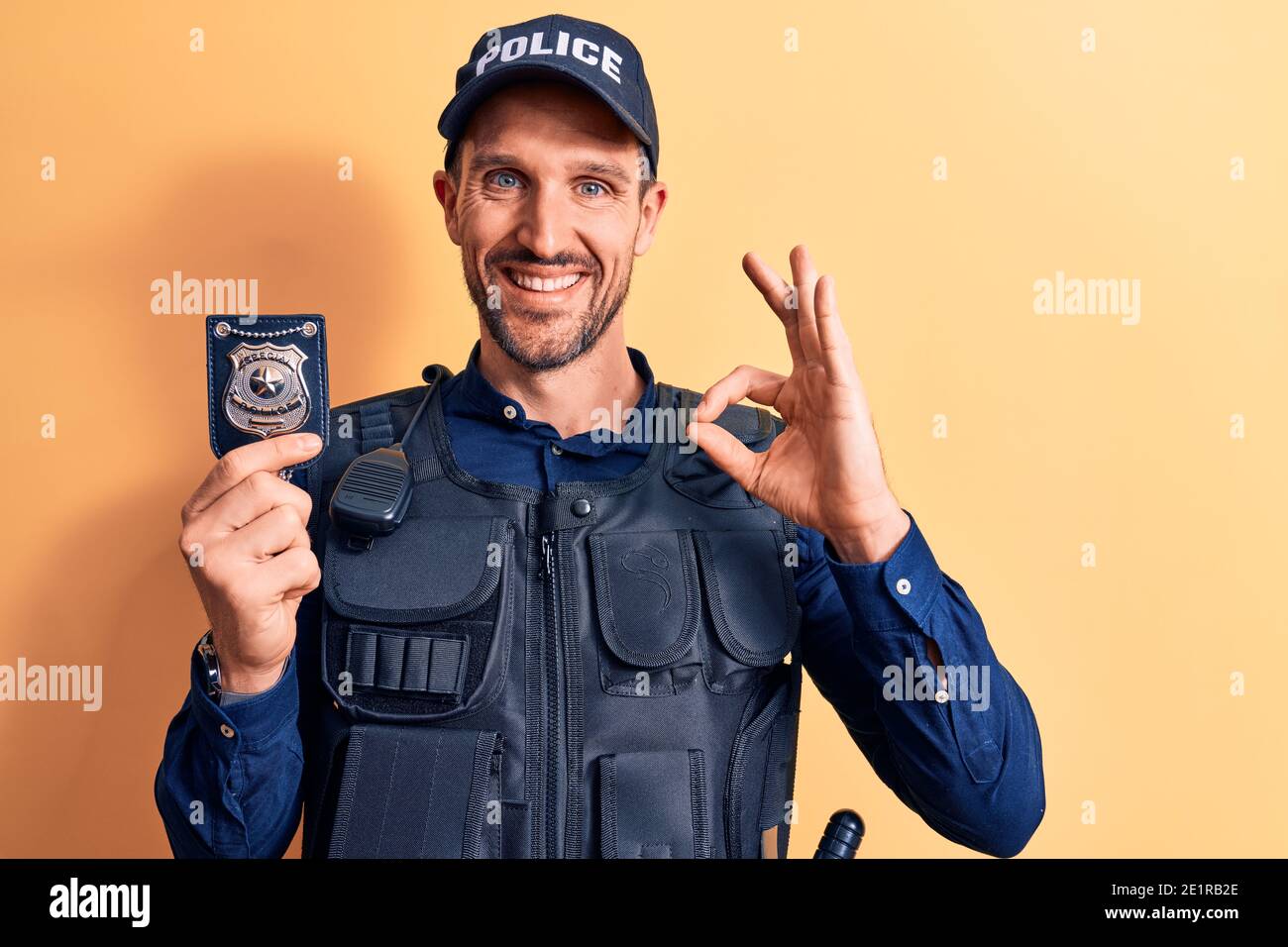 Young handsome policeman wearing uniform and bulletprof holding police ...