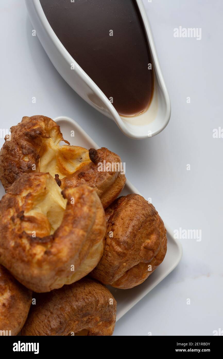 A top down view of a stack of Yorkshire puddings on a white backdrop ...