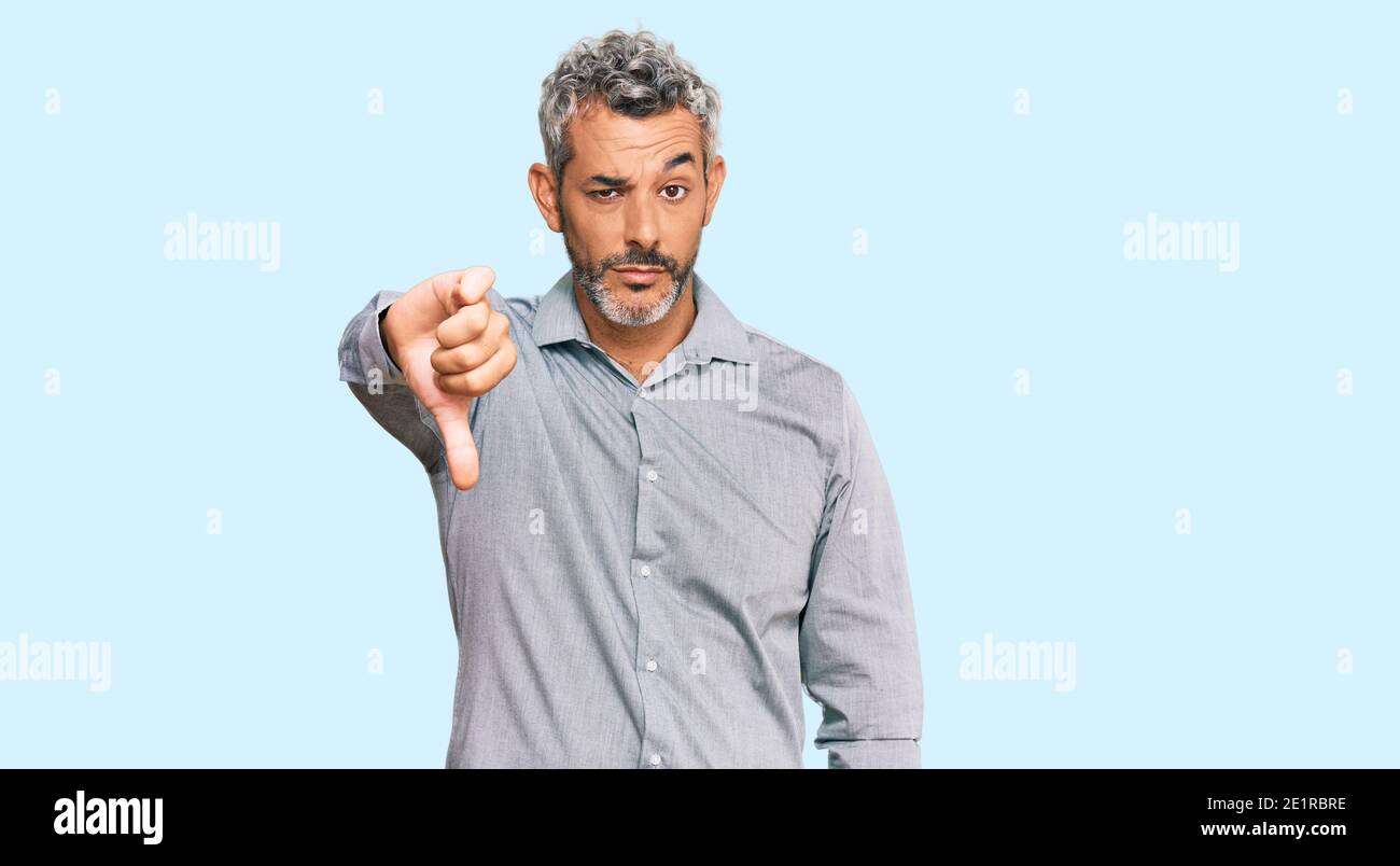 Middle age grey-haired man wearing casual clothes looking unhappy and ...