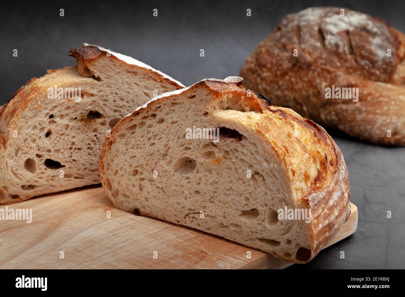 Sliced sourdough bread on dark cement background Stock Photo - Alamy