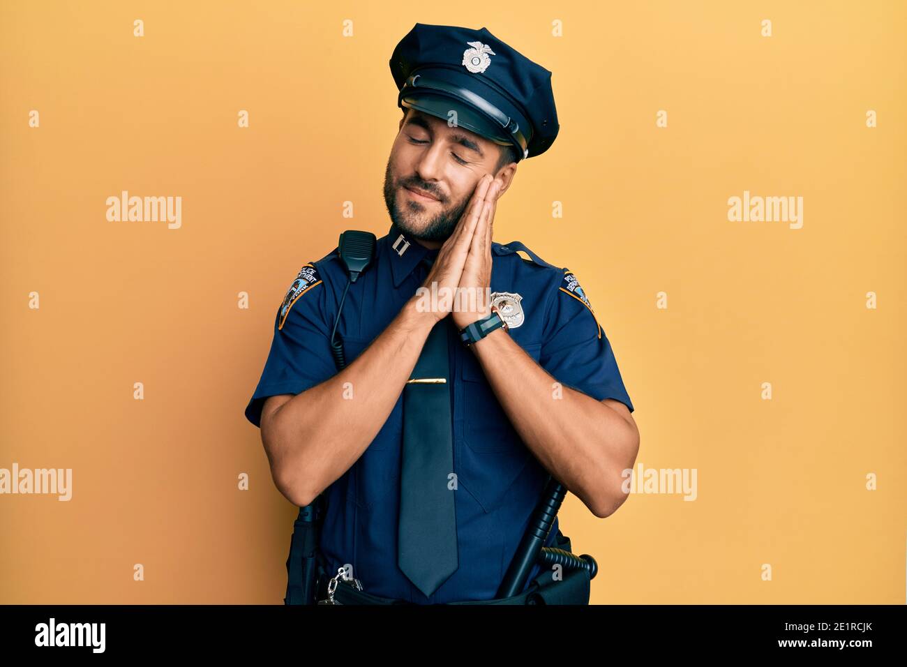 Handsome hispanic man wearing police uniform sleeping tired dreaming ...