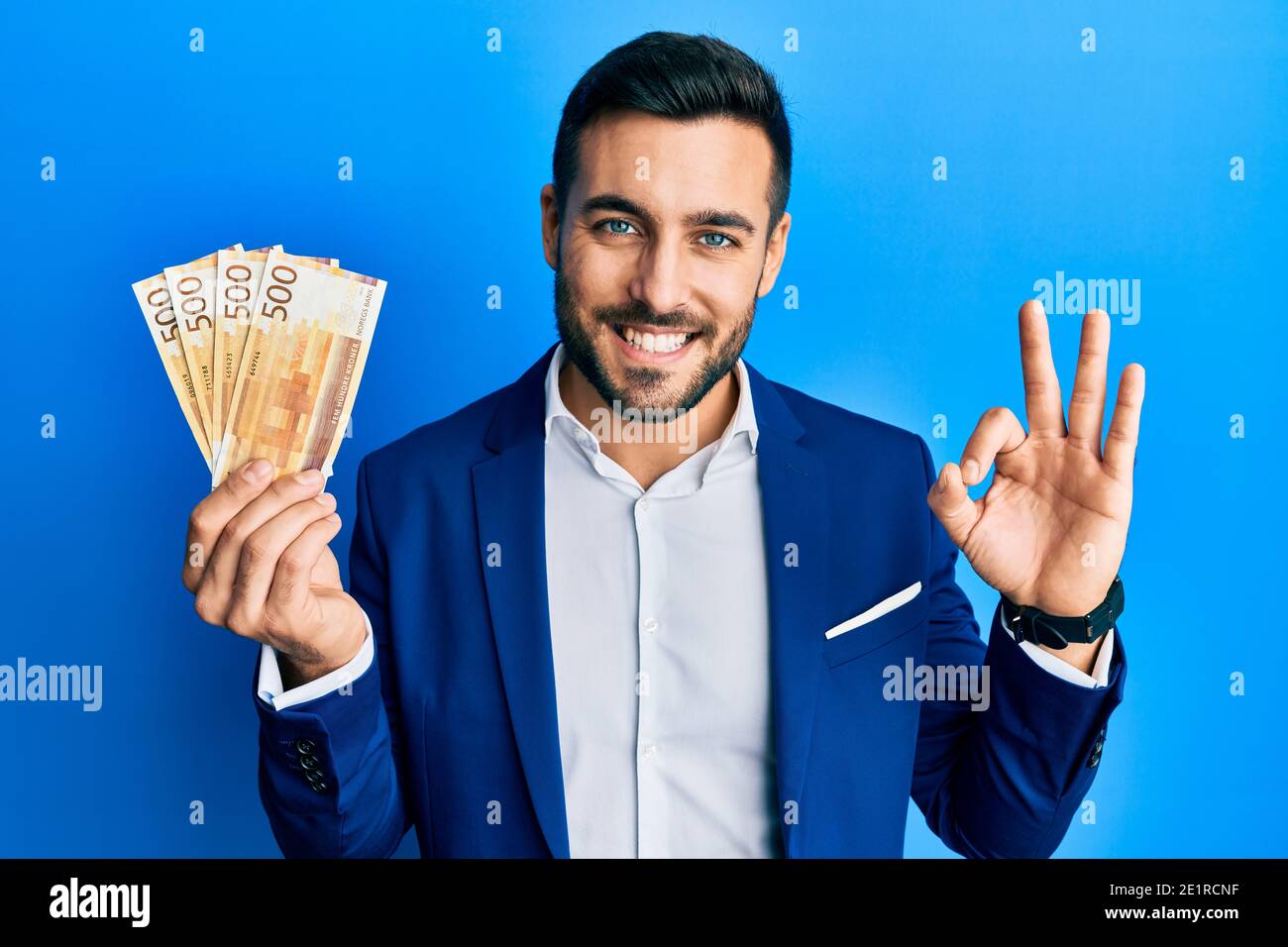Young hispanic businessman wearing business suit holding norwegian ...