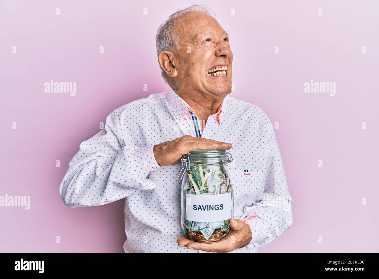 Senior caucasian man holding jar with savings angry and mad screaming ...