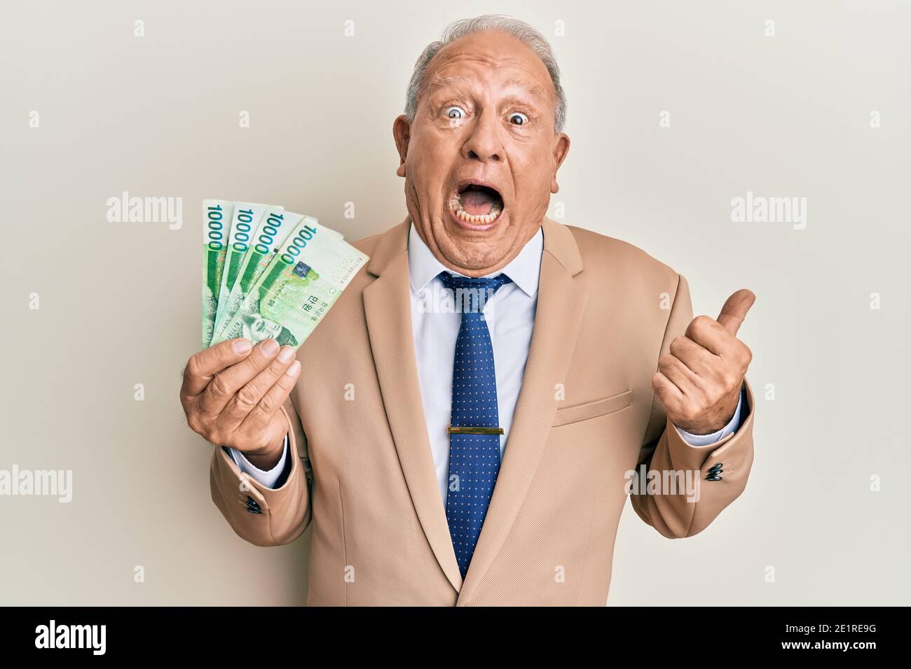 Senior caucasian man holding 10000 south korean won banknotes pointing ...