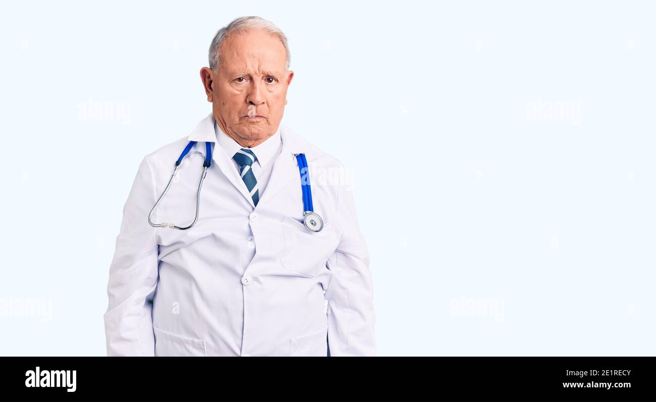 Senior handsome grey-haired man wearing doctor coat and stethoscope ...
