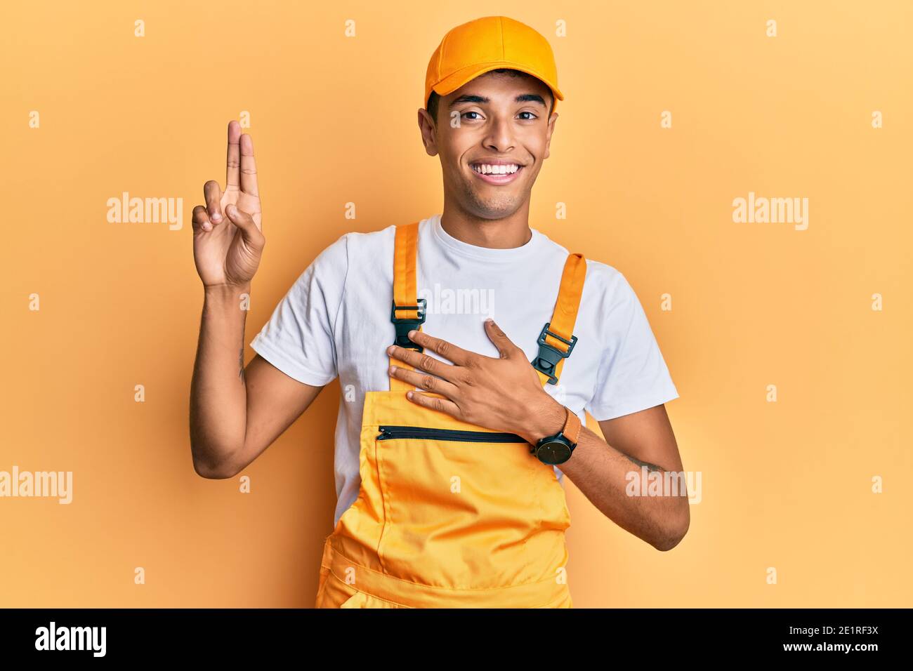 Young handsome african american man wearing handyman uniform over ...