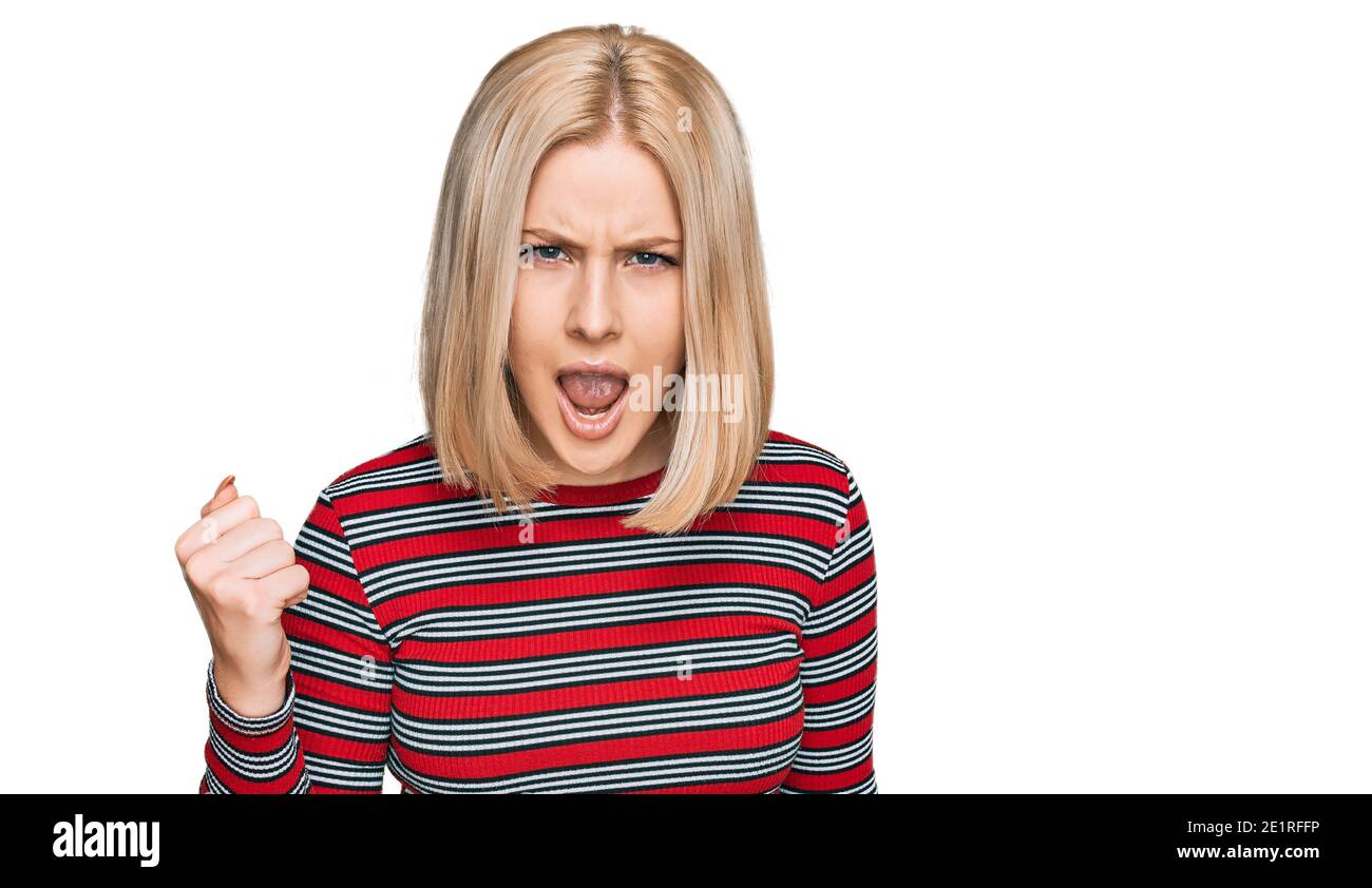 Young blonde woman wearing casual clothes angry and mad raising fist ...