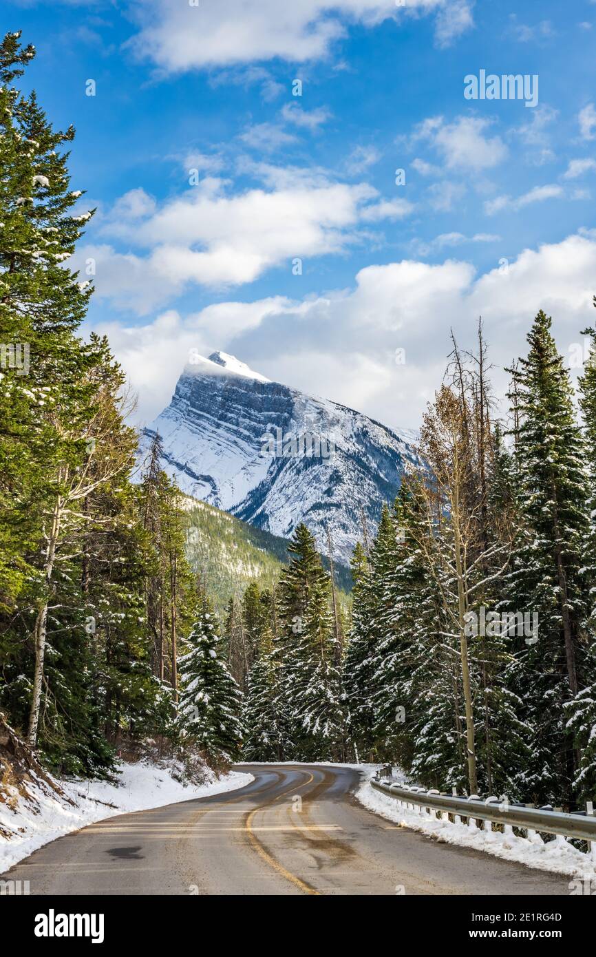 Snow-covered Mount Rundle with snowy forest mountain road. Mount ...