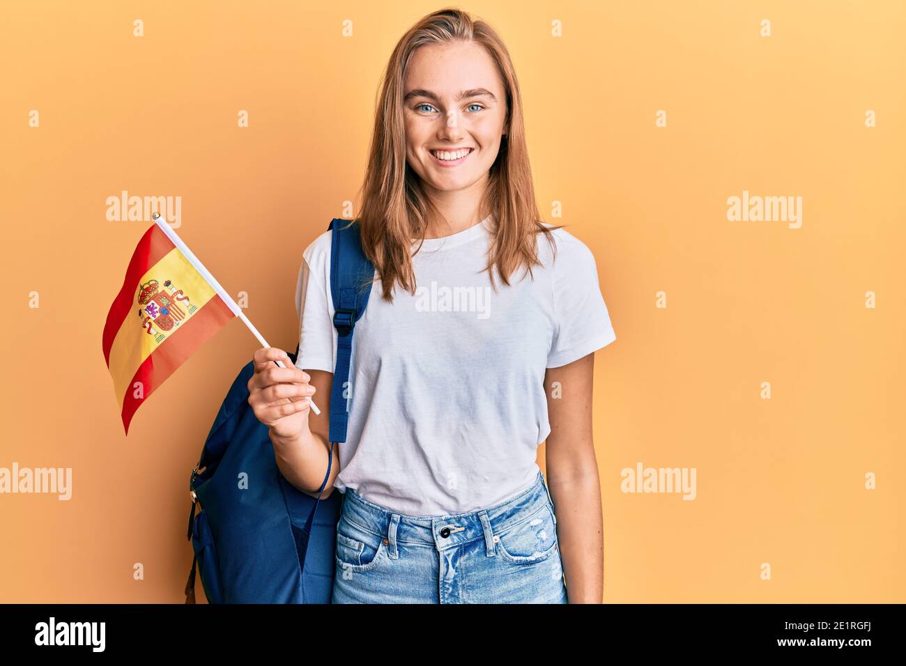 Beautiful blonde woman exchange student holding spanish flag looking ...