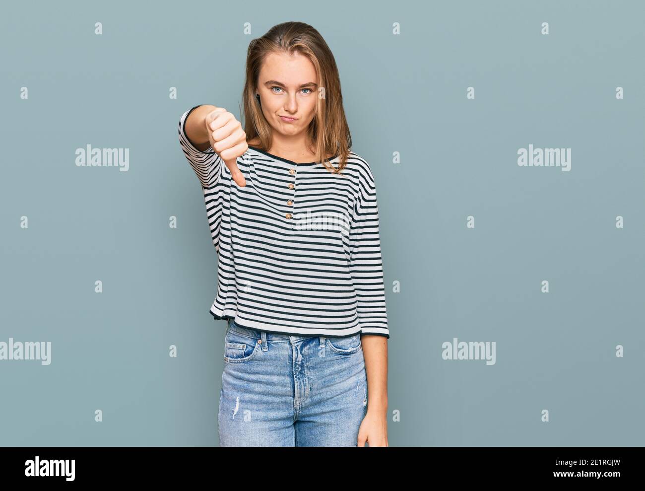 Beautiful blonde woman wearing casual clothes looking unhappy and angry ...