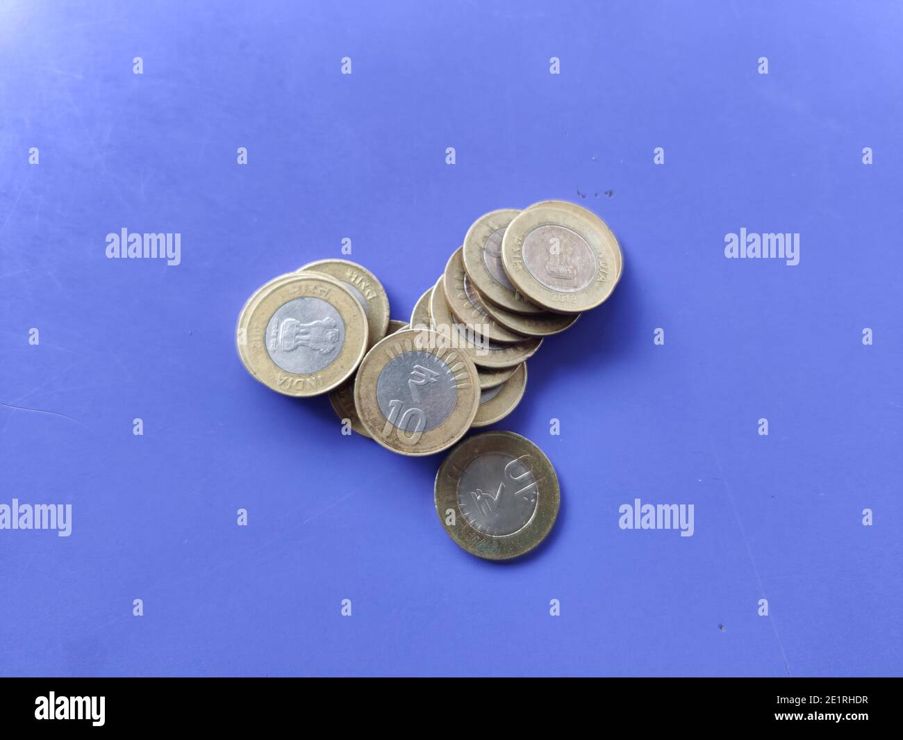 A bunch of Indian rupees ten coins kept on table with blue background ...