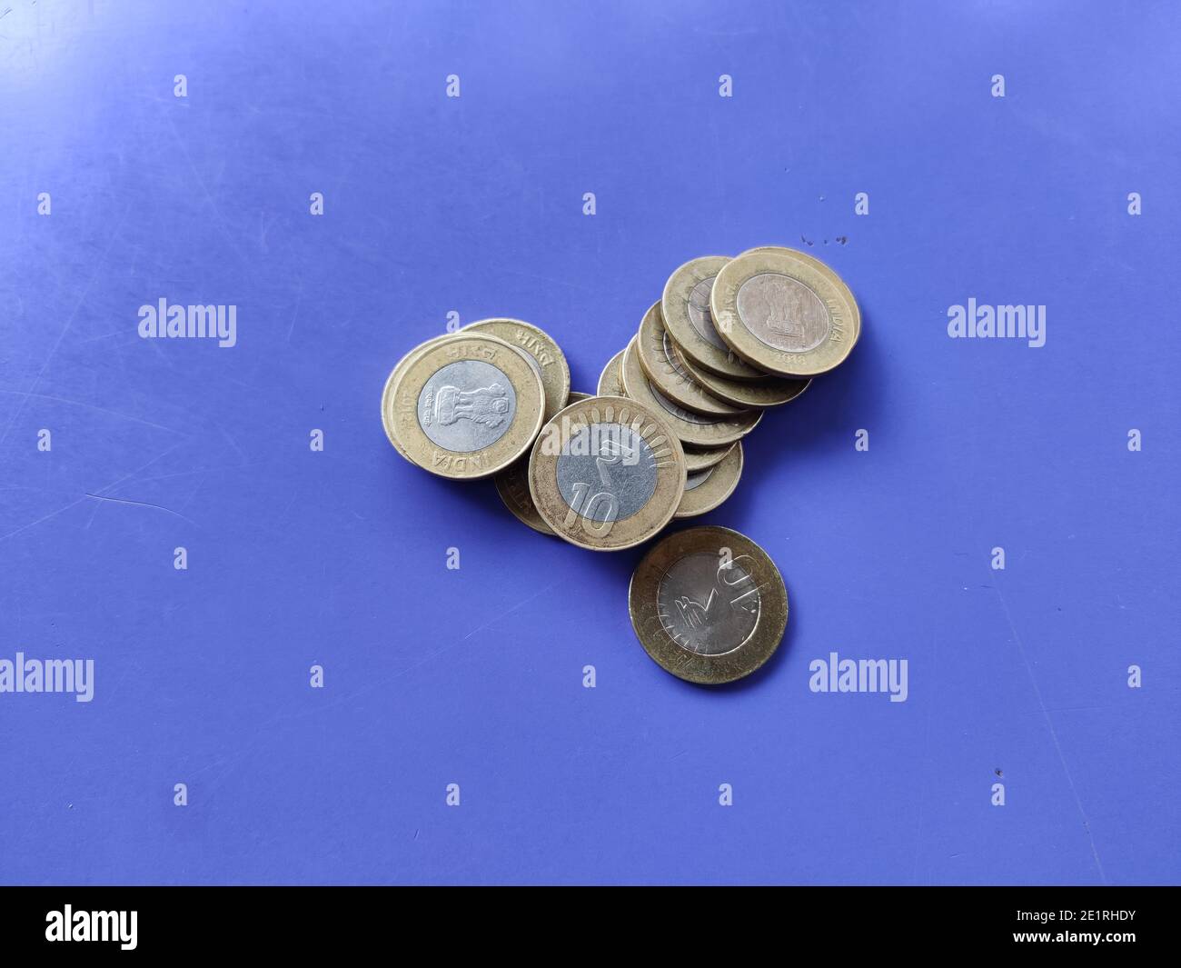 A bunch of Indian rupees ten coins kept on table with blue background ...