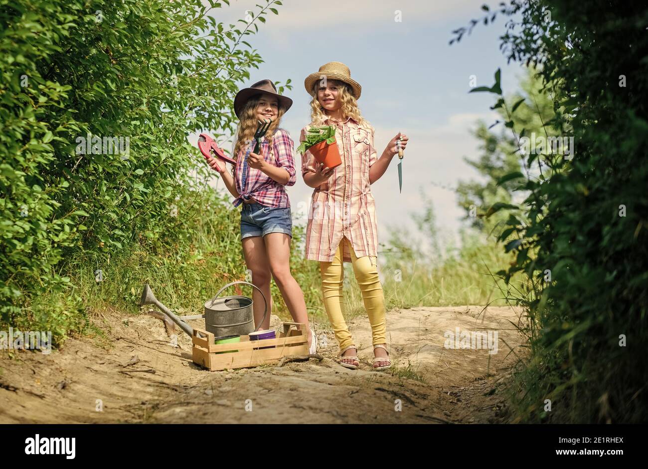 Taking care of plants. Girls with gardening tools. Sisters helping at ...