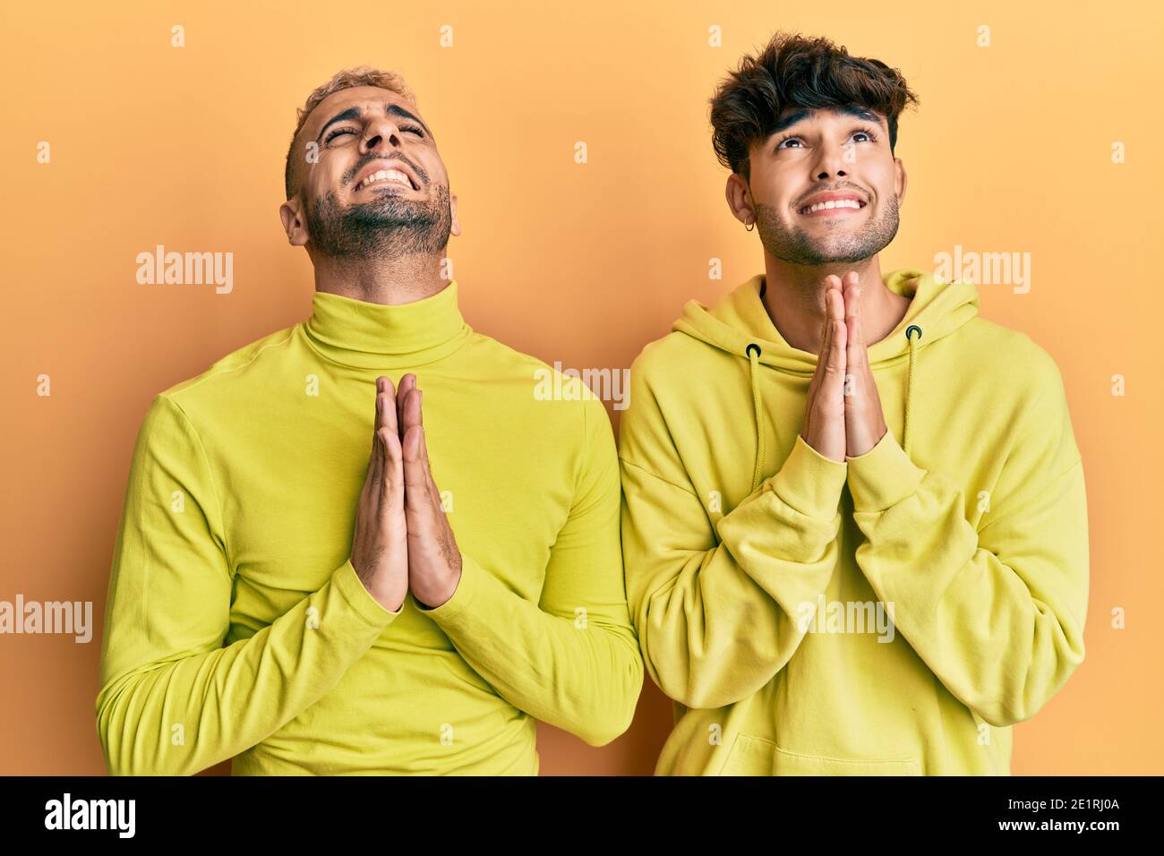 Homosexual gay couple standing together wearing yellow clothes begging ...