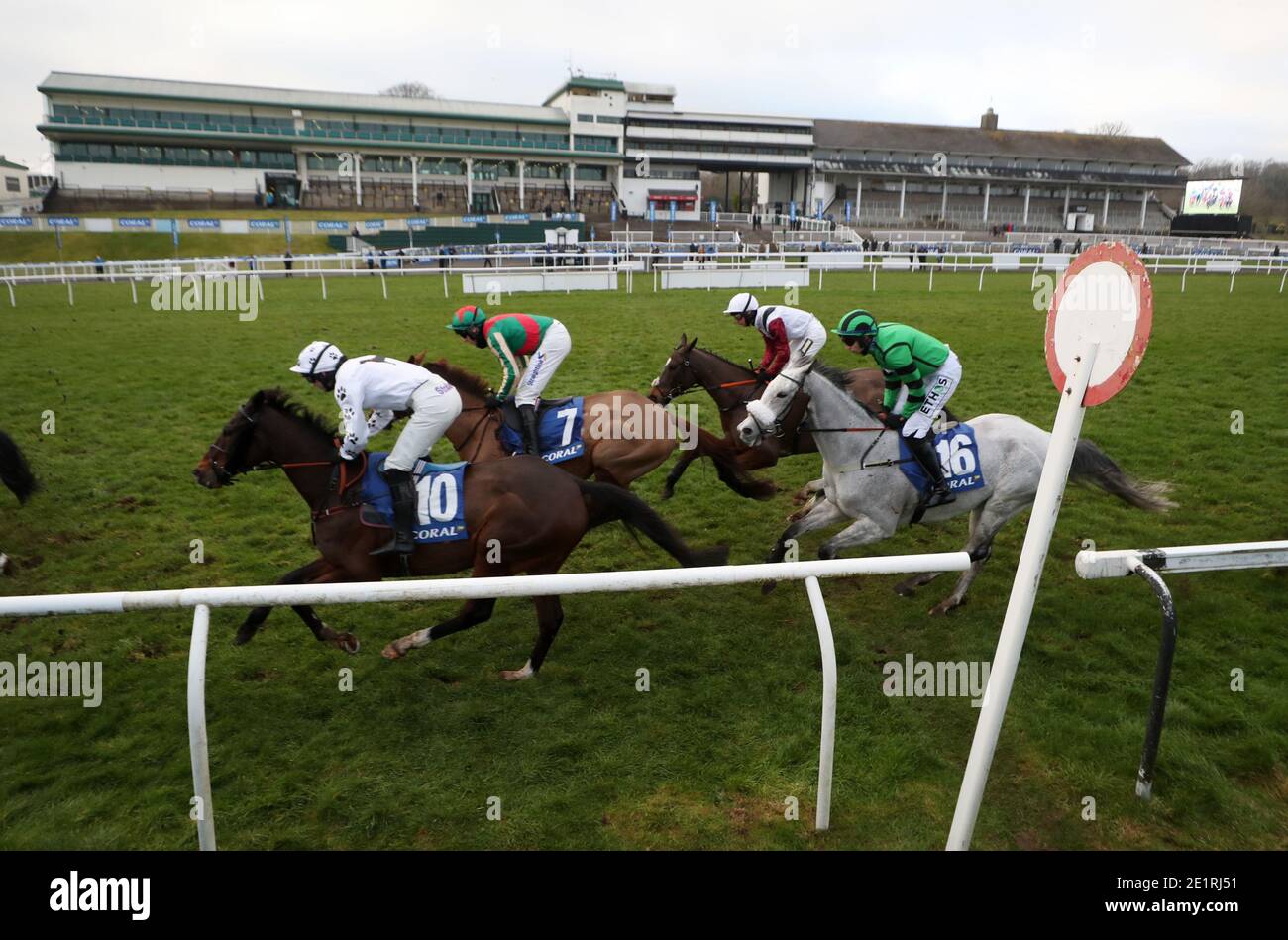 Runners and riders pass the empty grandstand during the Coral Welsh ...