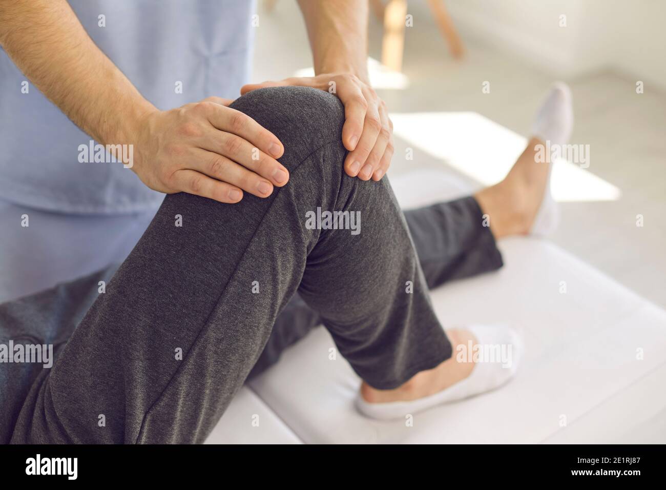 Hands of professional doctor osteopath checking patients knee during ...