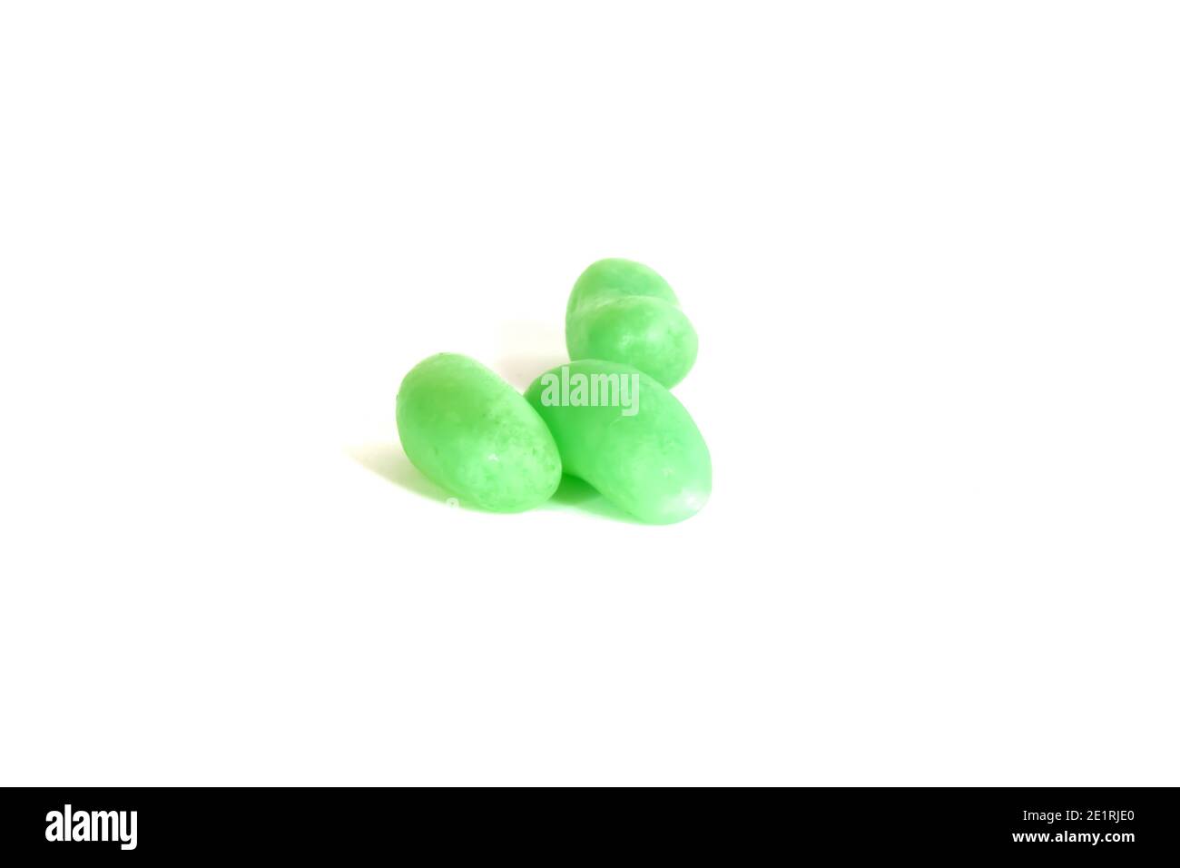 Small green candies isolated on white background Stock Photo - Alamy