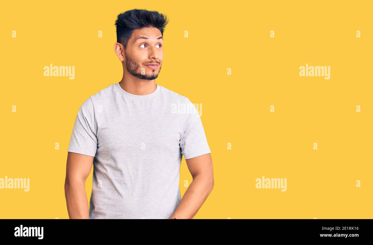 Handsome latin american young man wearing casual tshirt smiling looking ...