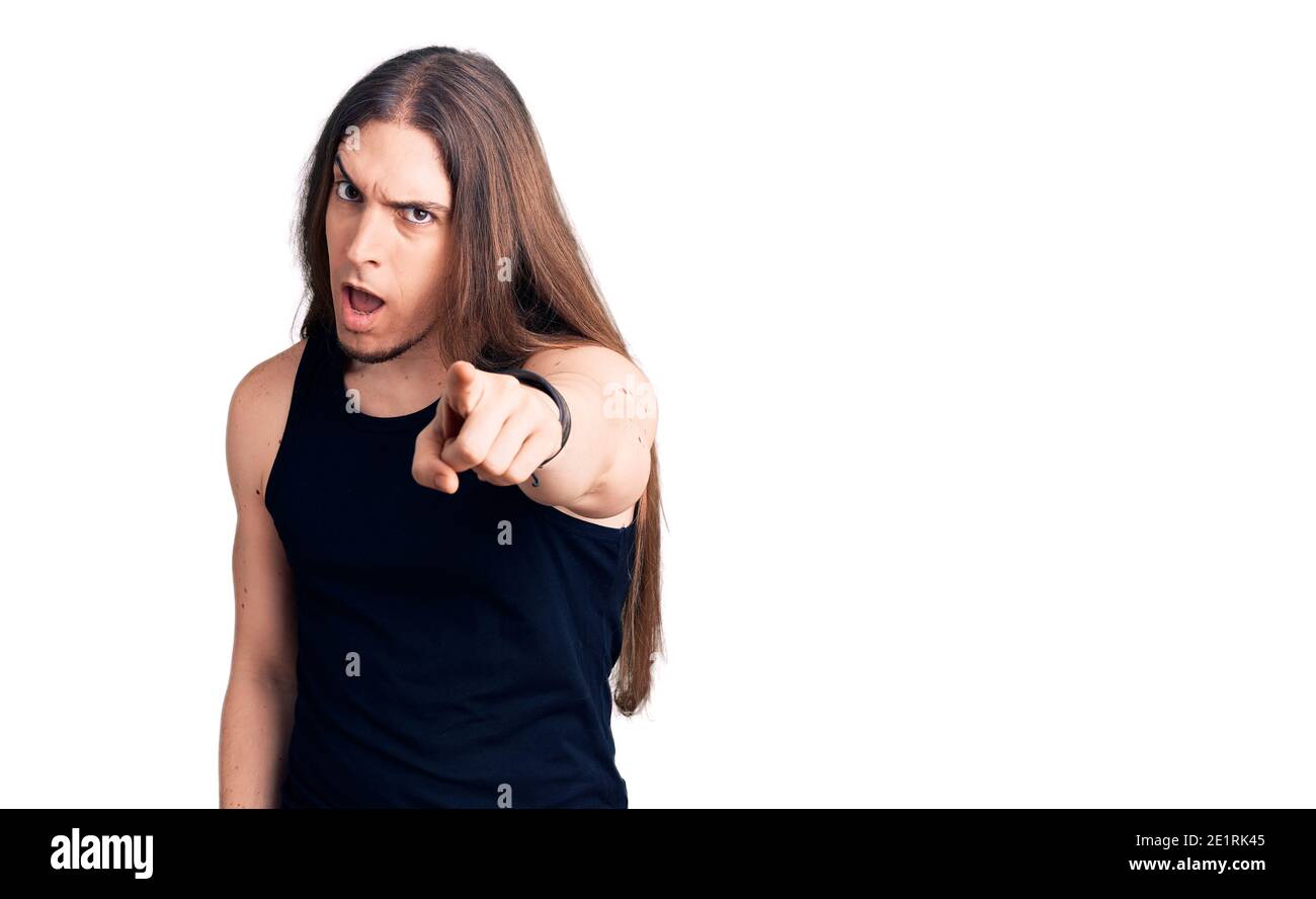 Young adult man with long hair wearing goth style with black clothes ...