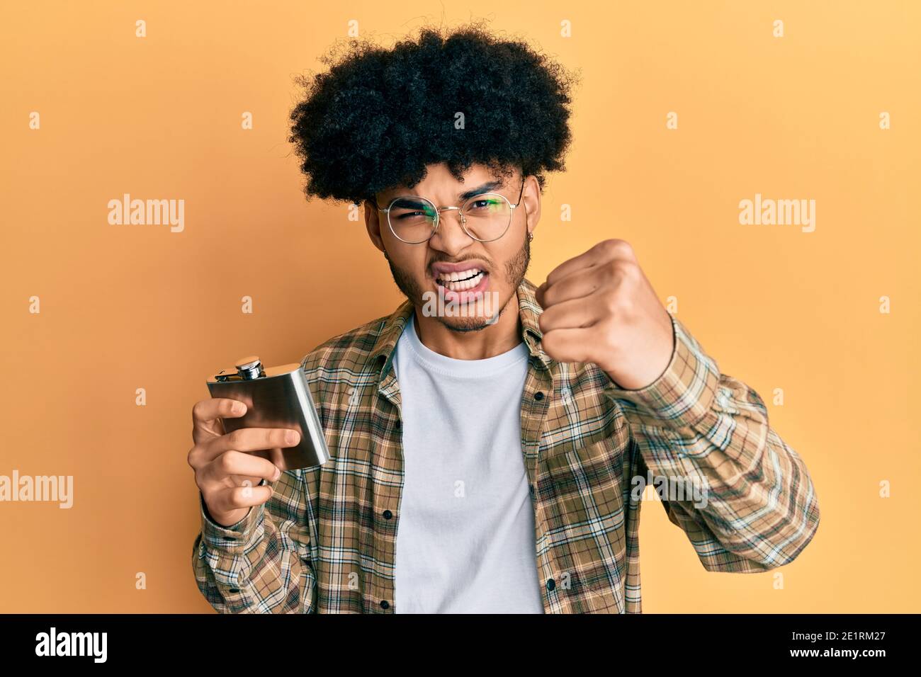 Young african american man with afro hair drinking alcohol from whiskey ...