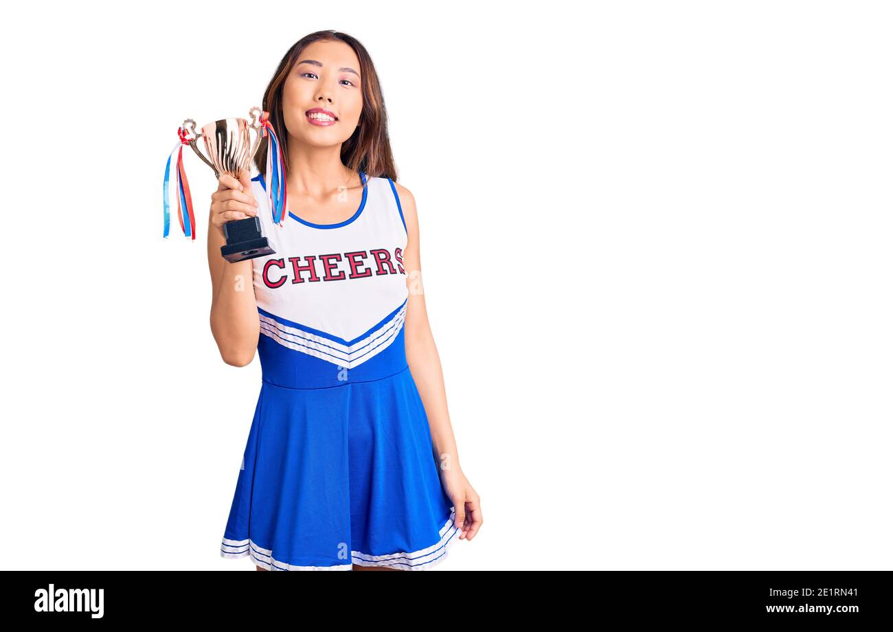 Youn beautiful asian girl wearing cheerleader uniform holding champion ...