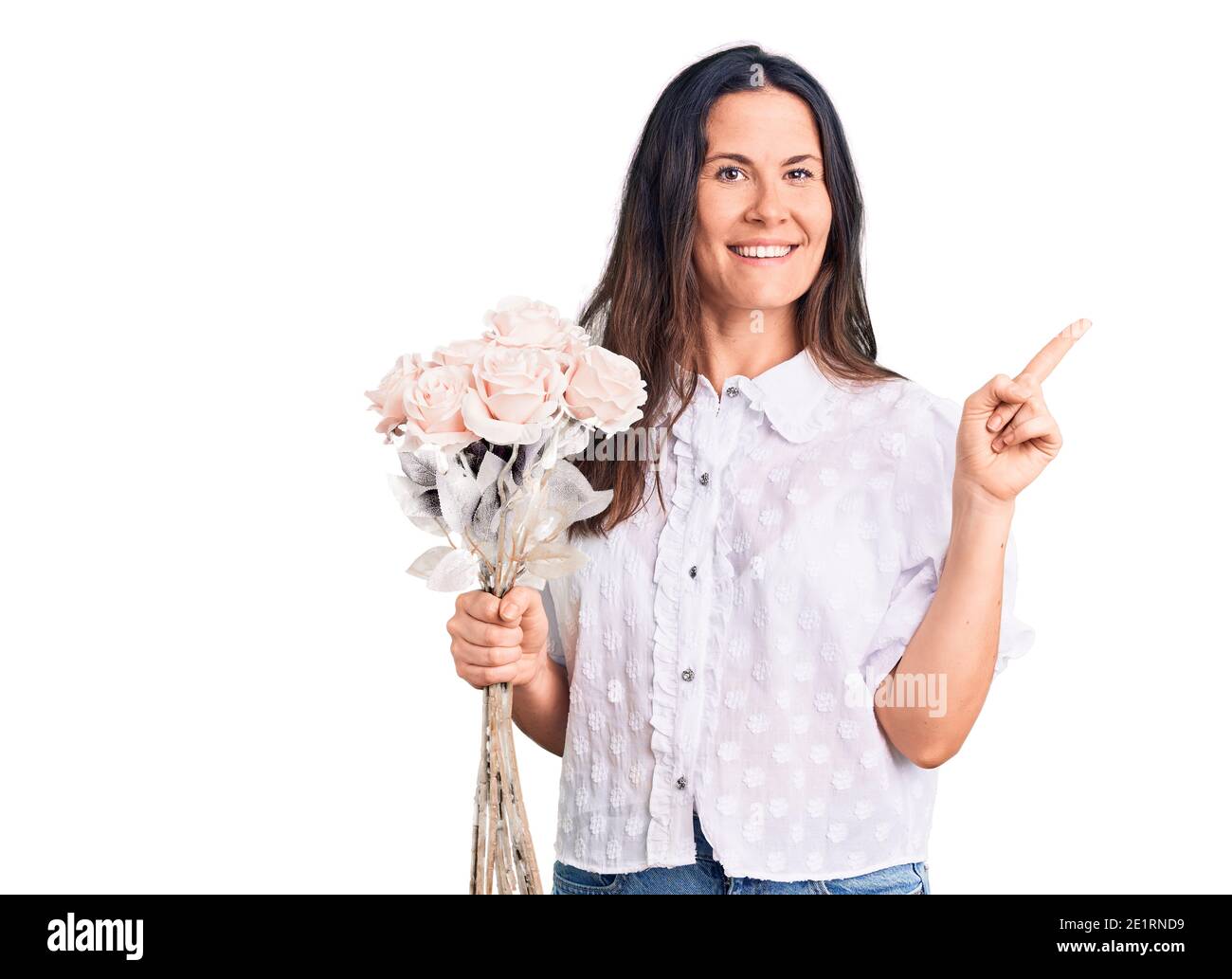 Young beautiful brunette woman holding bouquet of flowers smiling happy ...