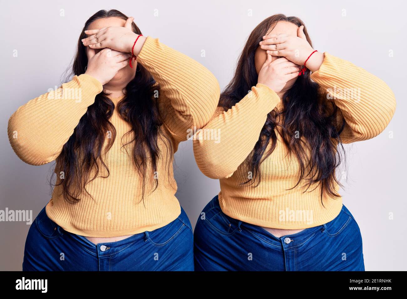 Young plus size twins wearing casual clothes covering eyes and mouth ...