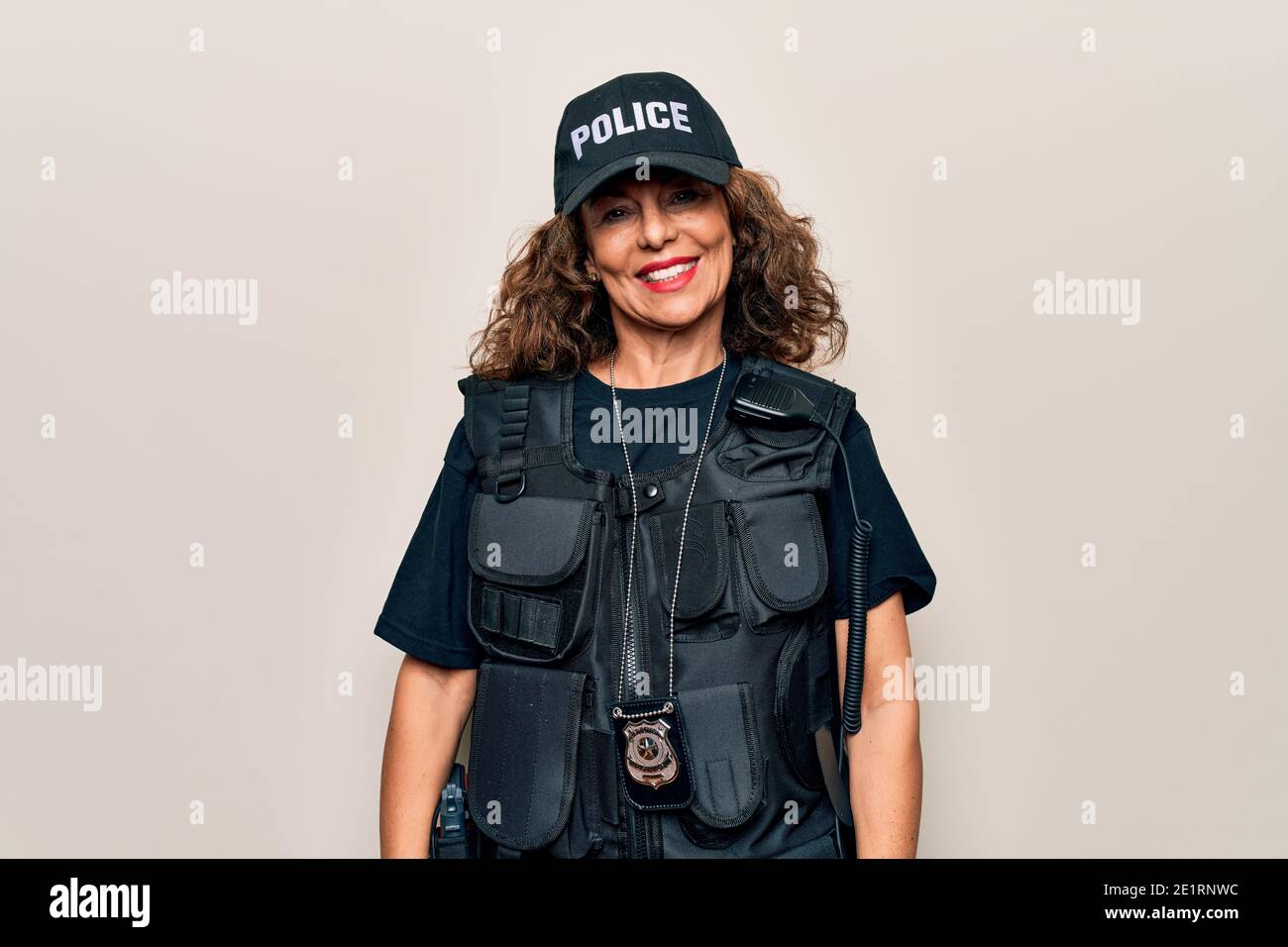 Middle age beautiful policewoman wearing bulletproof uniform and cap ...