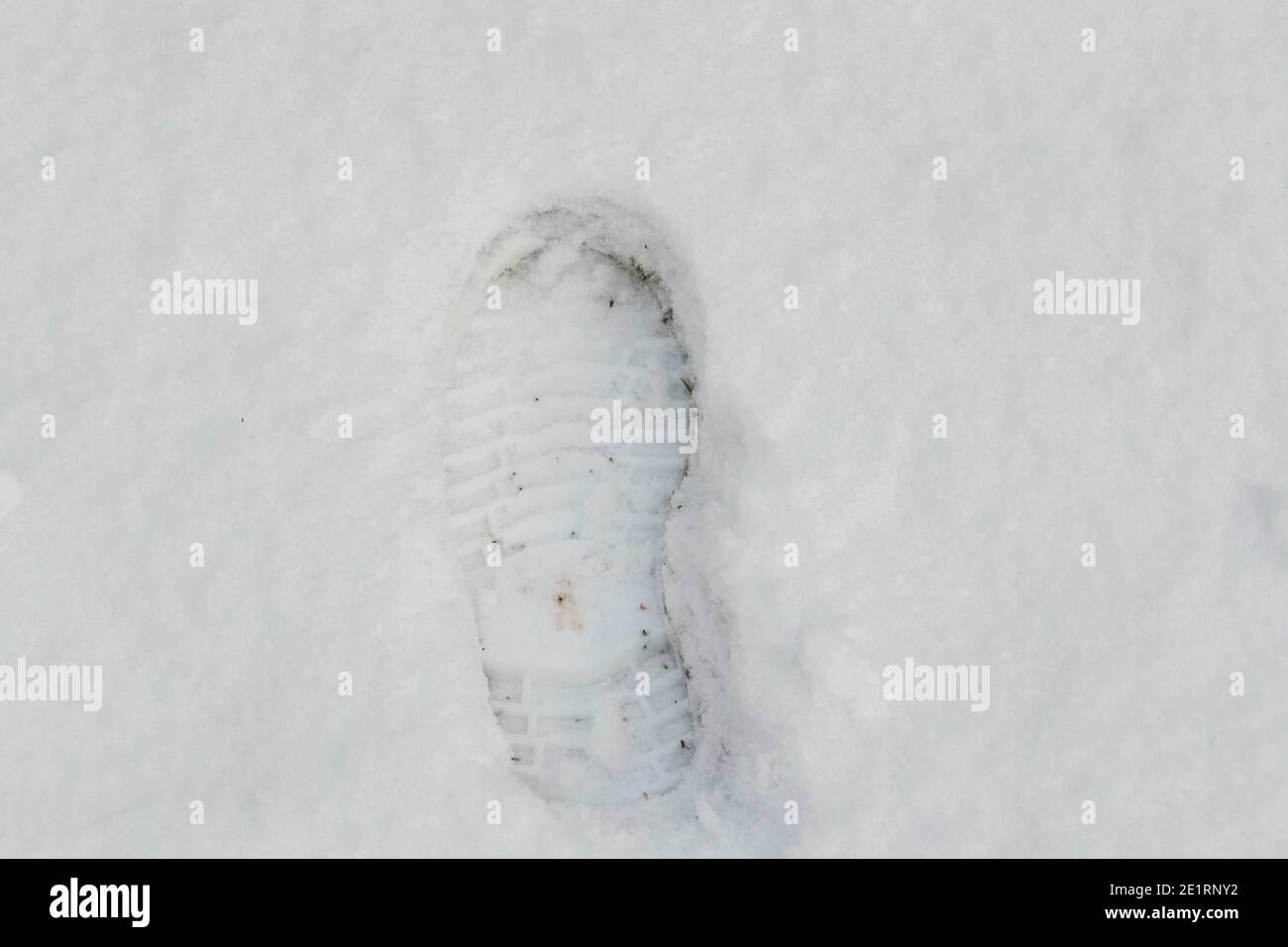 Close up view of shoe print on snowy asphalt road. Winter season ...