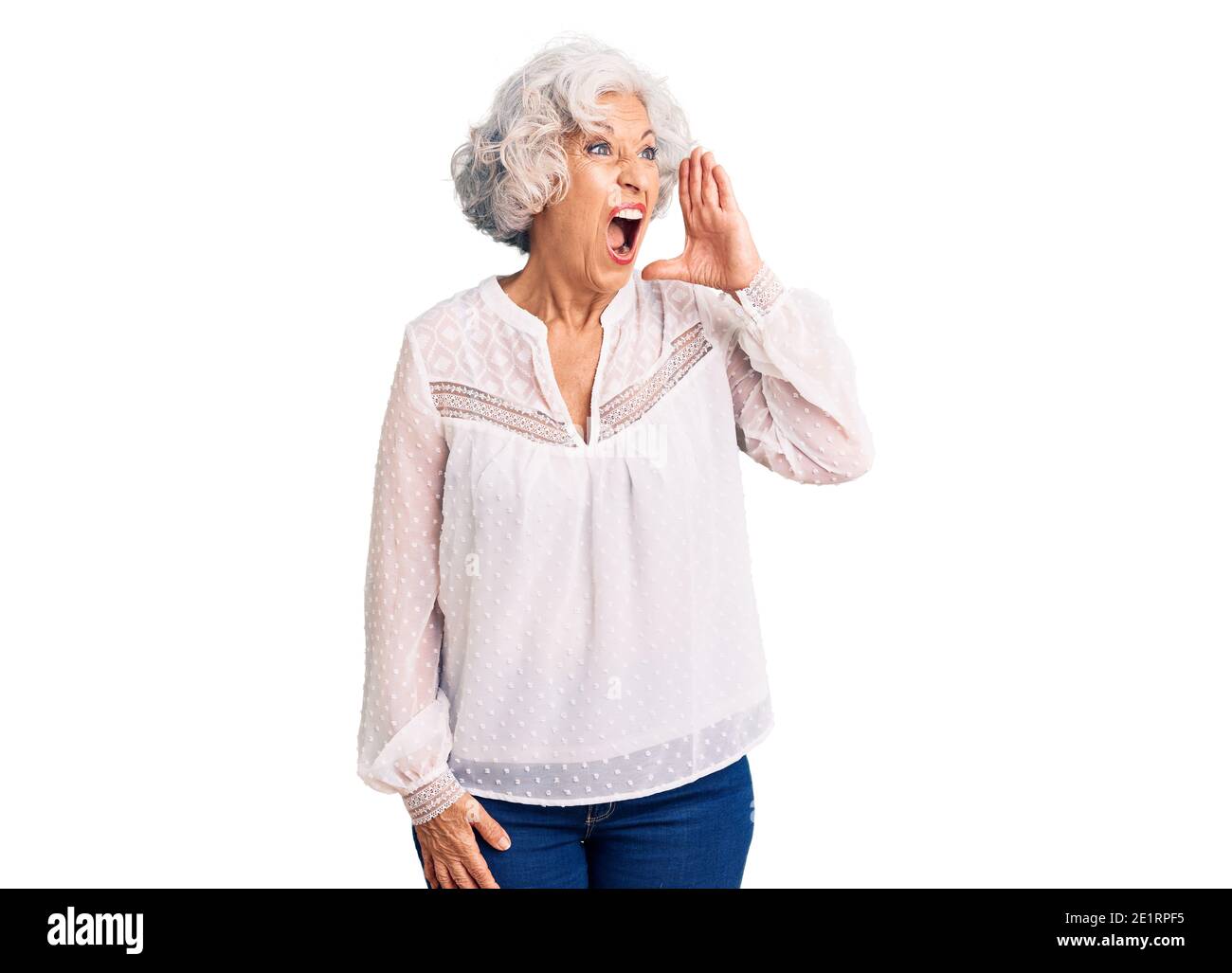 Senior grey-haired woman wearing casual clothes shouting and screaming ...