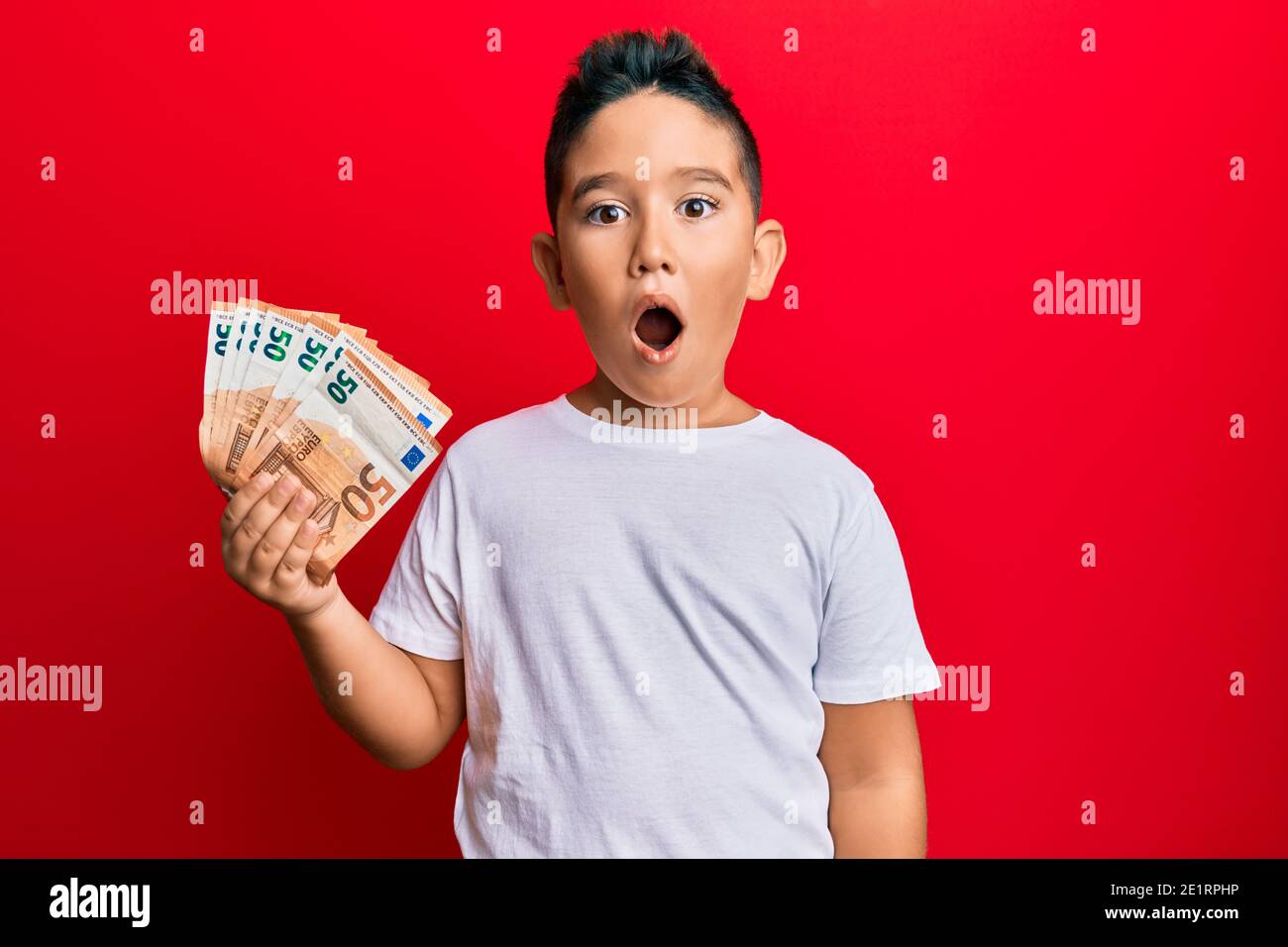 Little boy hispanic kid holding bunch of 50 euro banknotes scared and ...