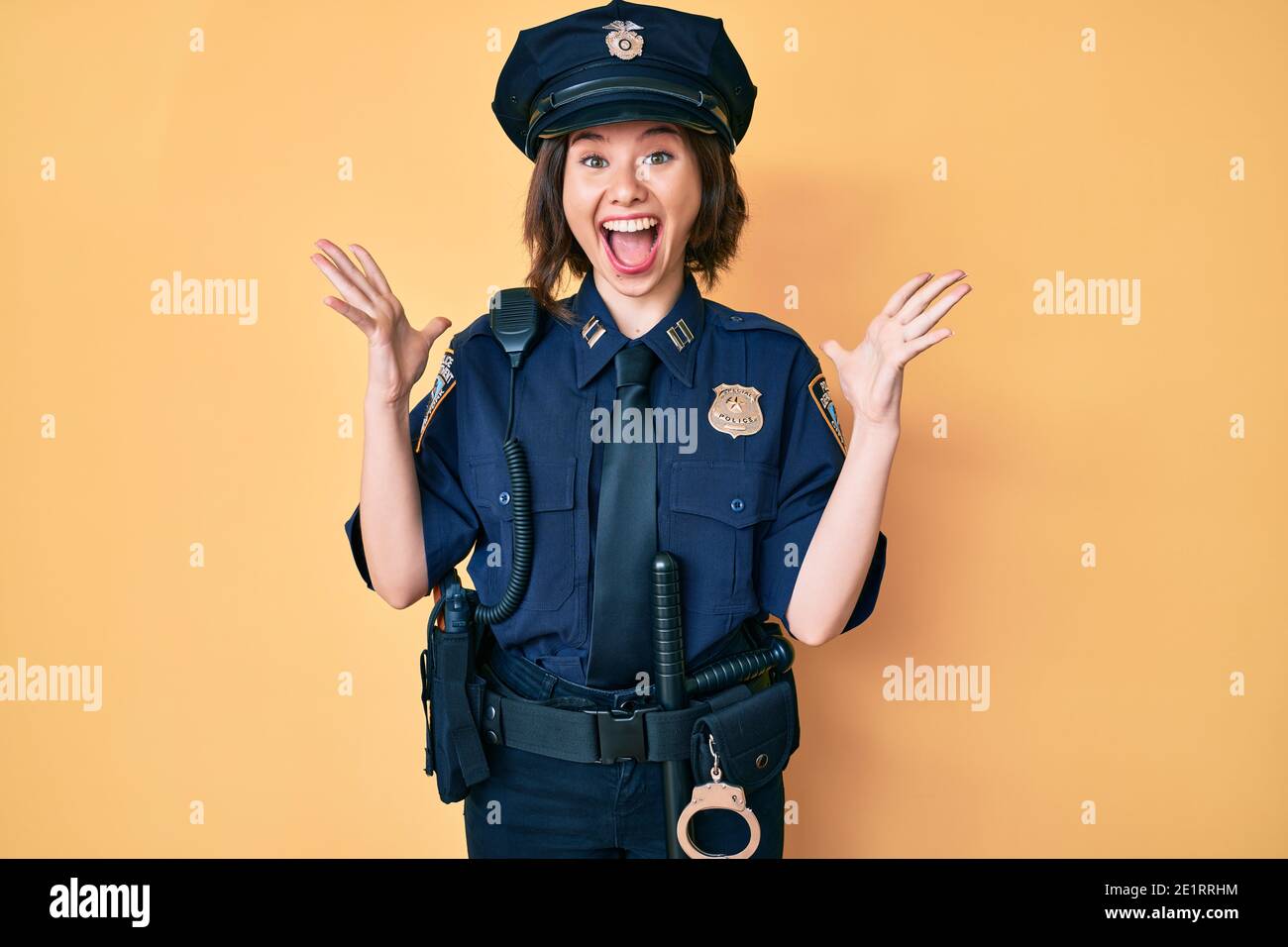 Young beautiful woman wearing police uniform celebrating crazy and ...