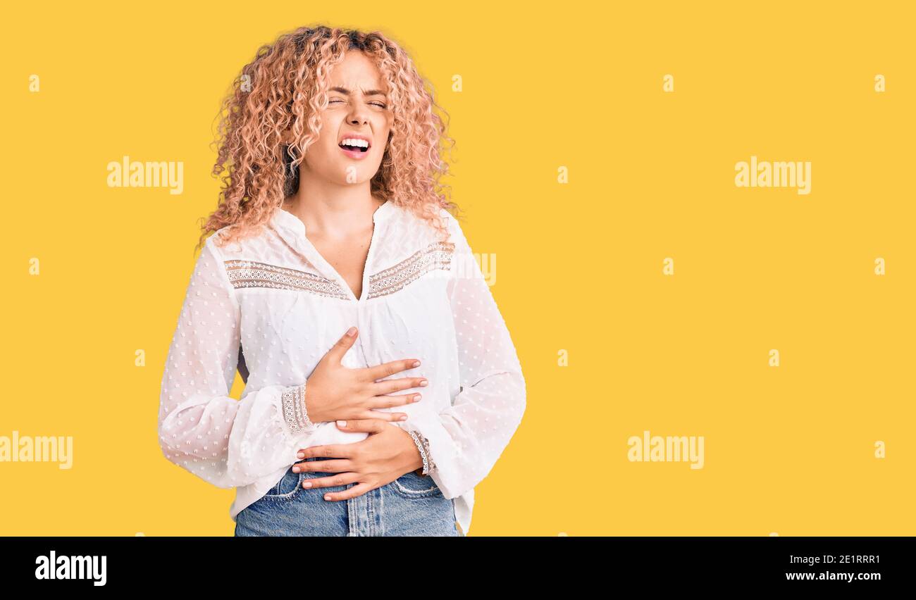 Young blonde woman with curly hair wearing elegant summer shirt with ...
