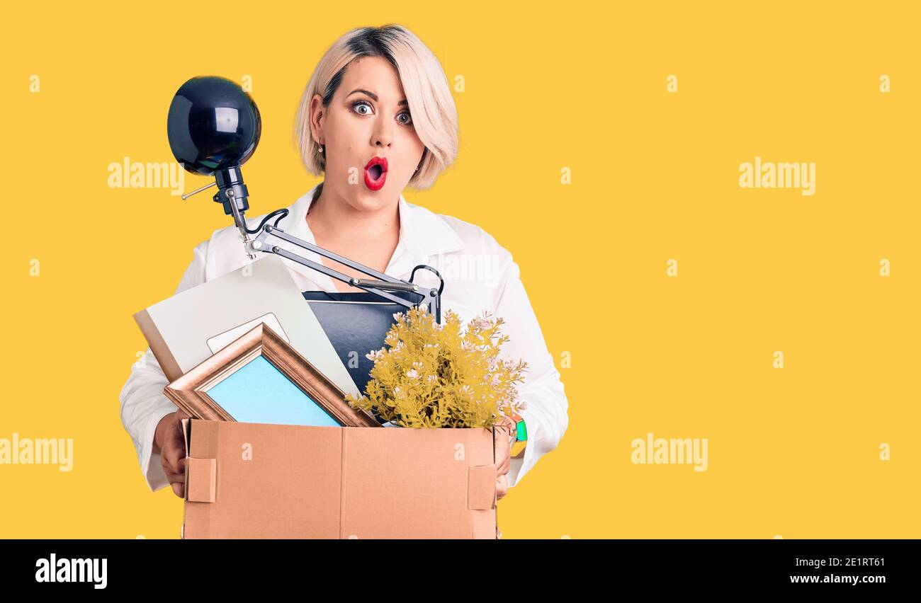 Young blonde plus size woman fired holding box scared and amazed with ...