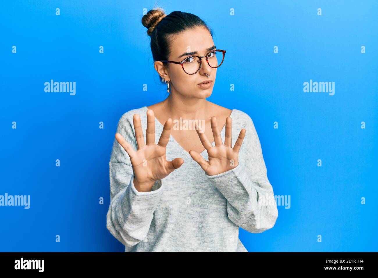 Young hispanic woman wearing casual clothes moving away hands palms ...