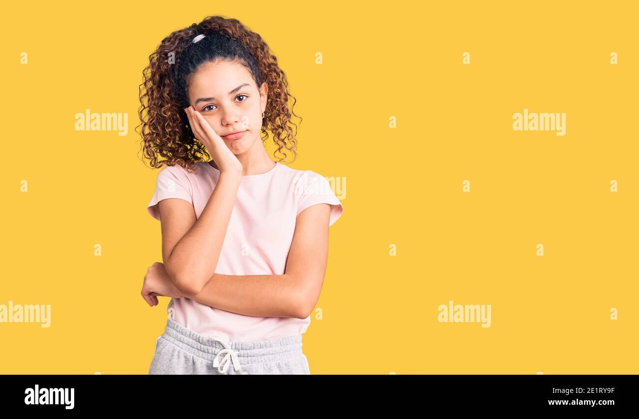 Beautiful kid girl with curly hair wearing casual clothes thinking ...
