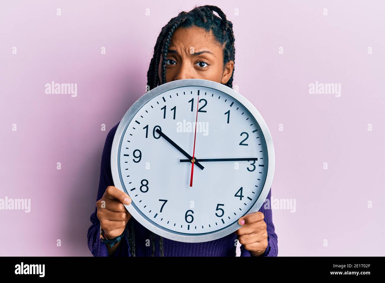 African american woman with braids holding big clock covering face ...