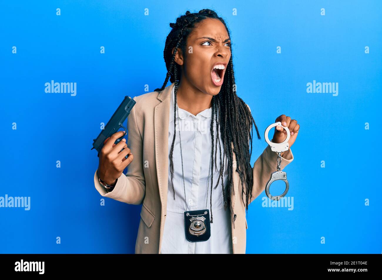 African American Police Woman Holding Gun And Handcuffs Angry And Mad