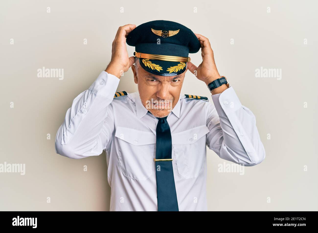 Handsome middle age mature man wearing airplane pilot uniform suffering ...