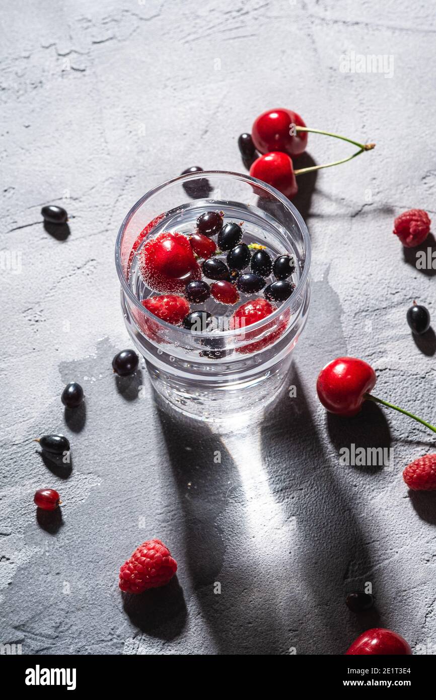 Fresh cold sparkling water drink with cherry, raspberry and currant ...