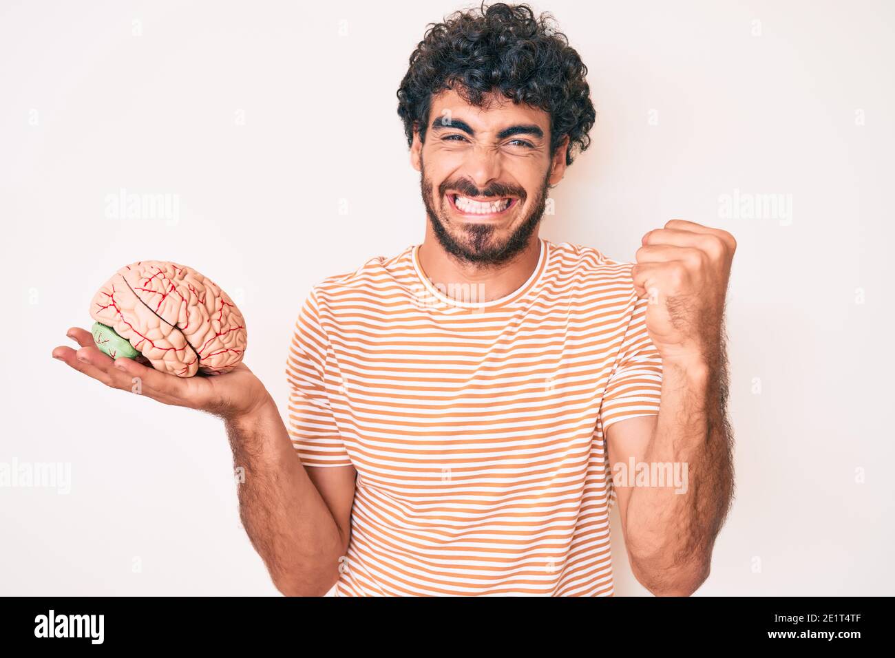 Handsome young man with curly hair and bear holding brain as mental ...