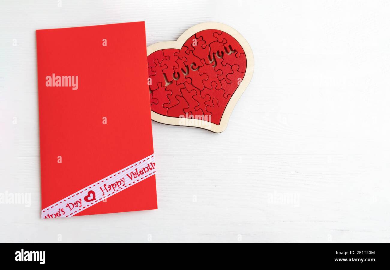 Envelope and heart assembled from puzzles on a white background with ...