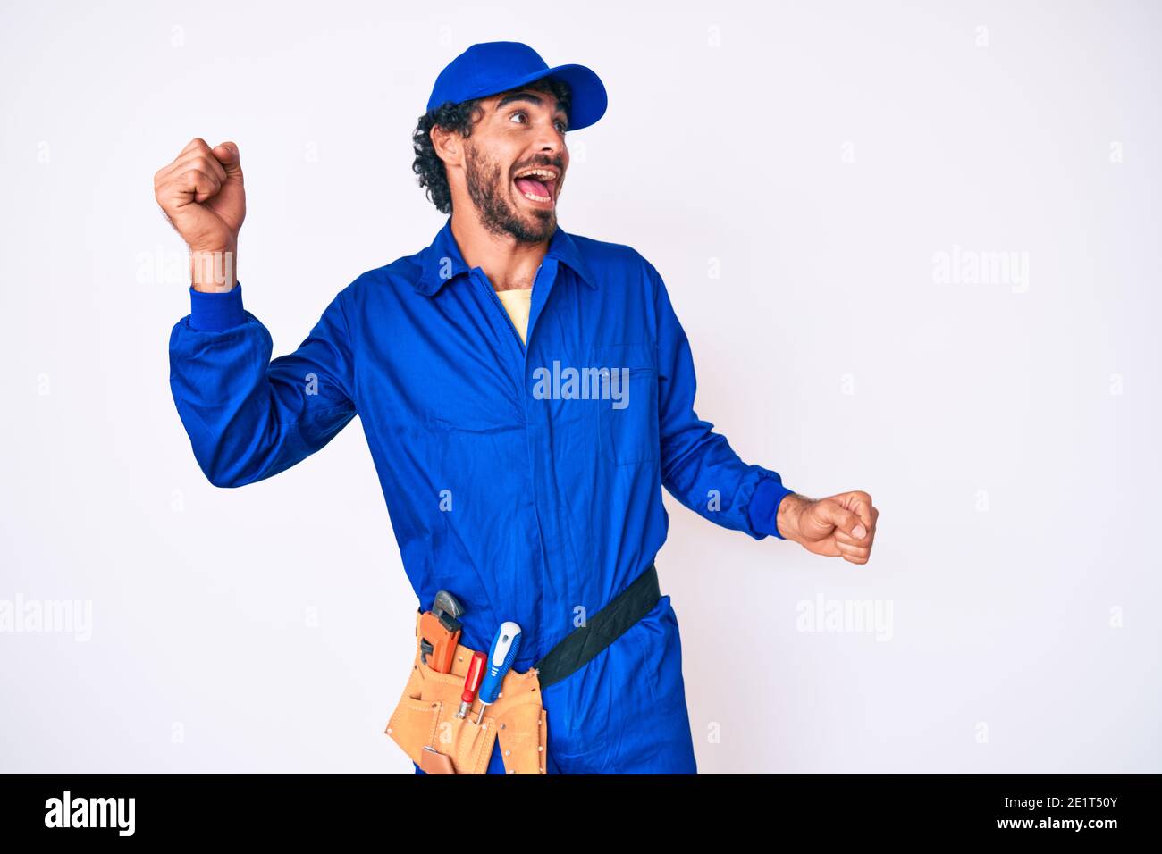 Handsome young man with curly hair and bear weaing handyman uniform ...