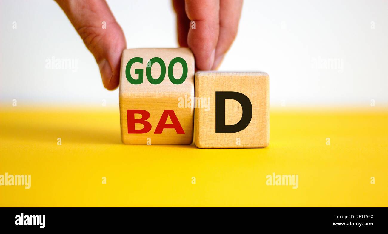 Good or bad symbol. Businessman hand turns a cube and changes the word ...