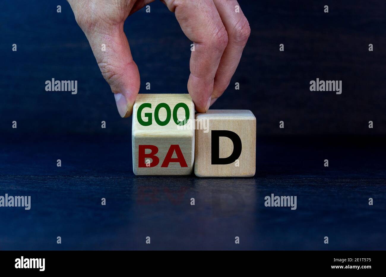 Good or bad symbol. Businessman hand turns a cube and changes the word ...