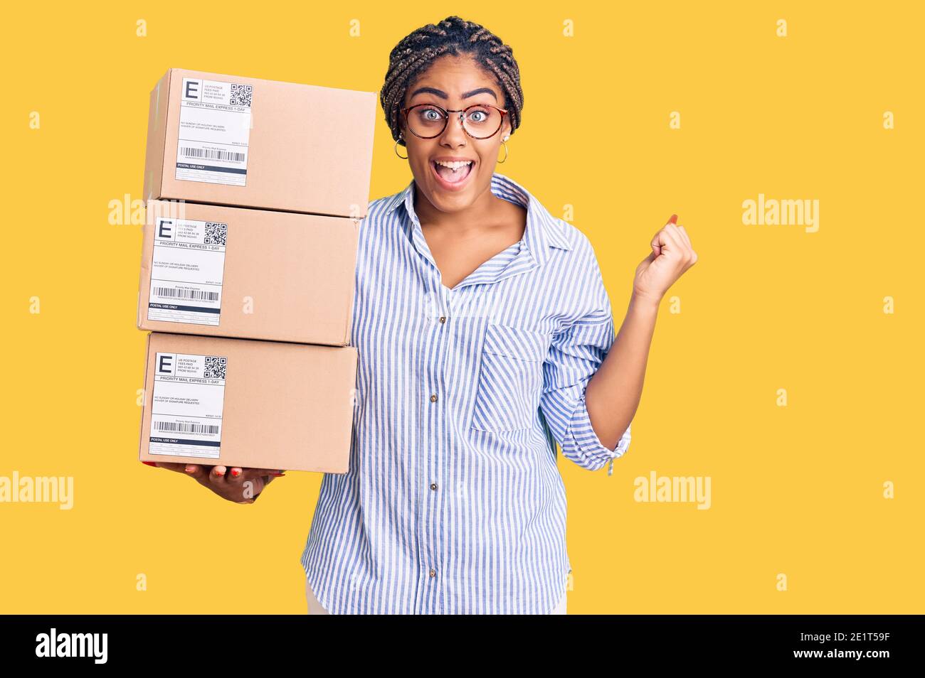 Young african american woman with braids holding delivery packages ...