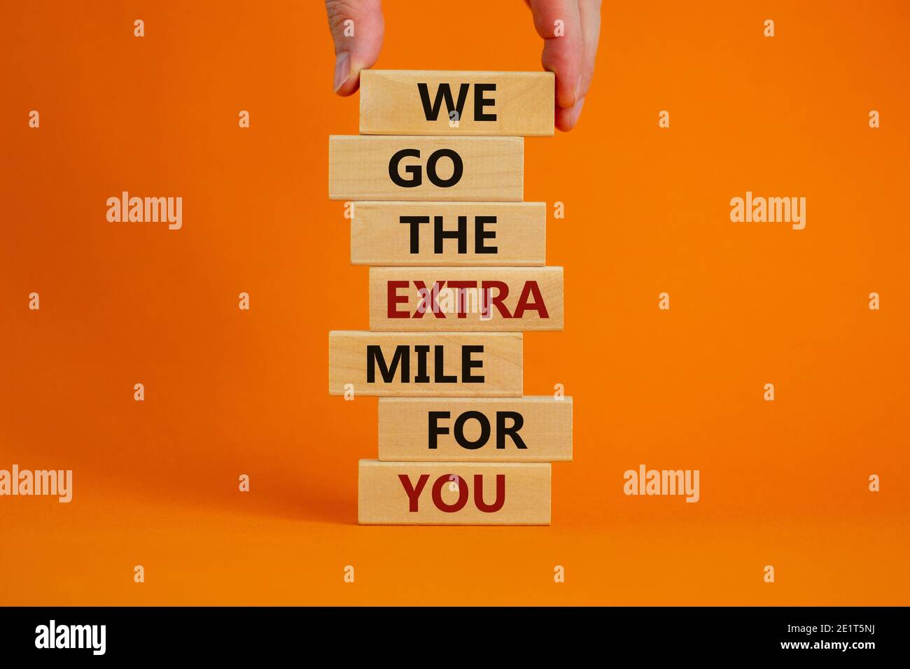 Go the extra mile symbol. Wooden blocks with words 'We go the extra ...